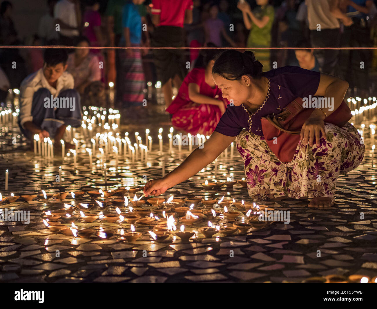 Yangon, Yangon Division, Myanmar. 28th Oct, 2015. A woman lights oil ...