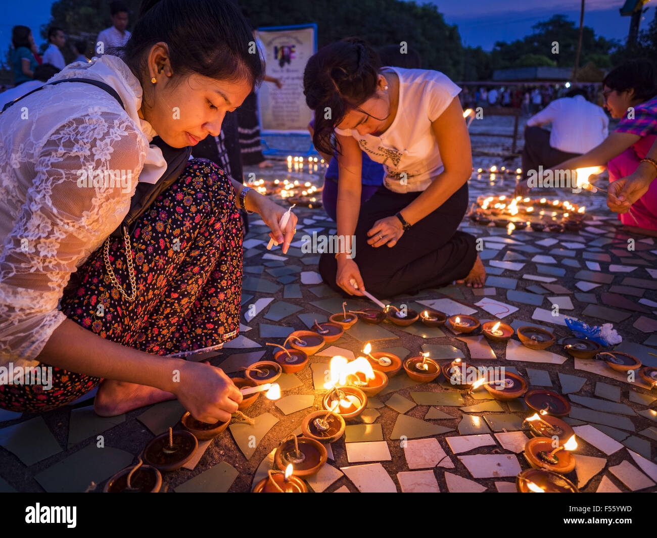 Yangon, Yangon Division, Myanmar. 28th Oct, 2015. Women light oil lamps ...
