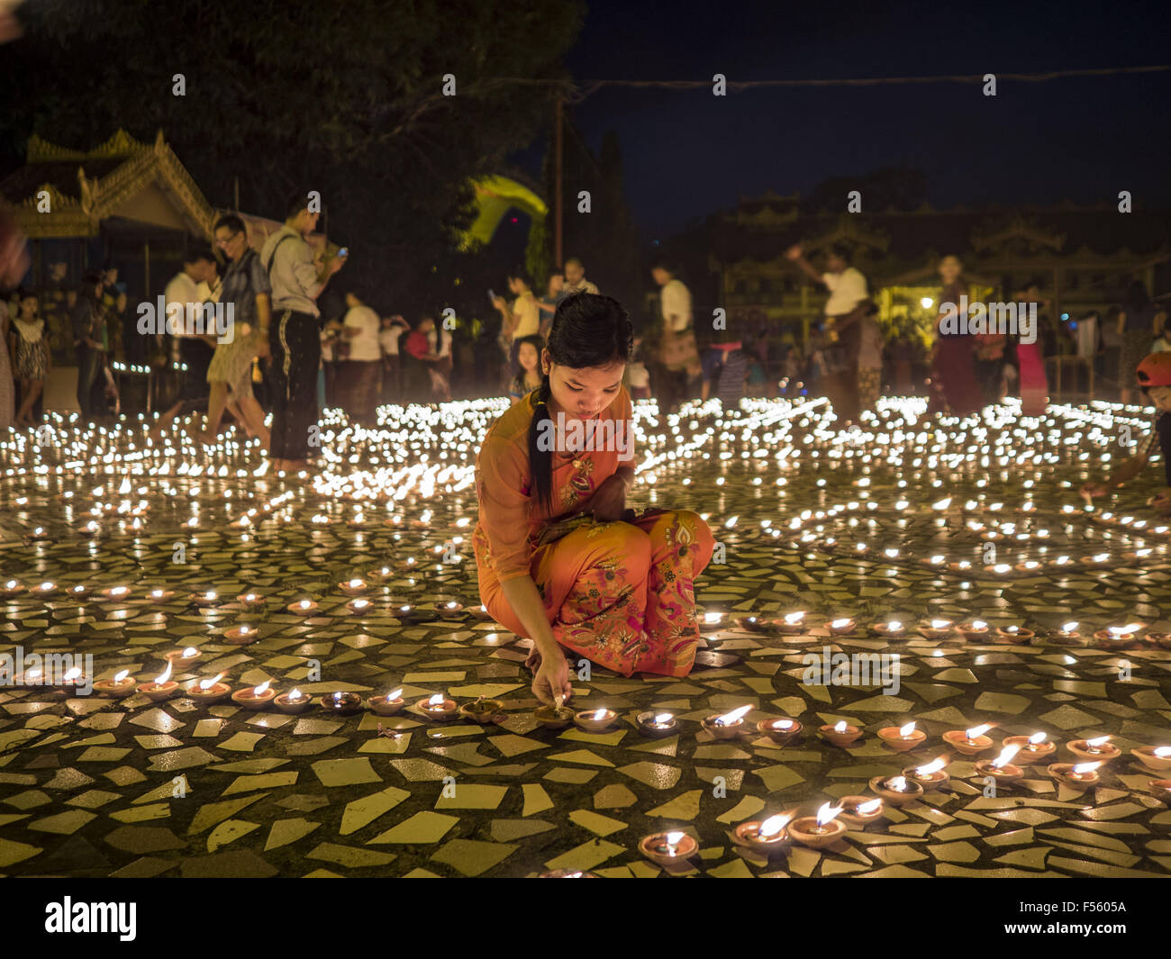 Yangon, Yangon Division, Myanmar. 28th Oct, 2015. A woman lights oil ...