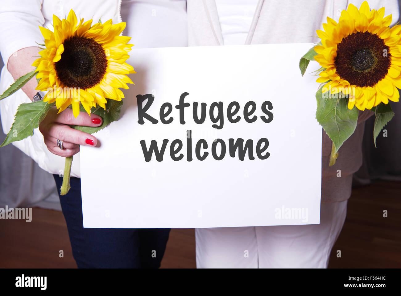 two female helpers welcome refugees Stock Photo - Alamy