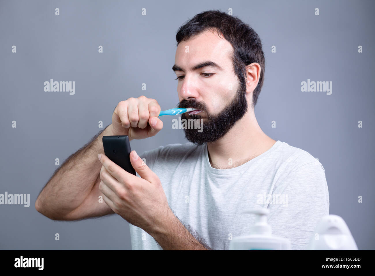 Man with Beard Washing His Teeth with a Toothbrush while Watching a ...