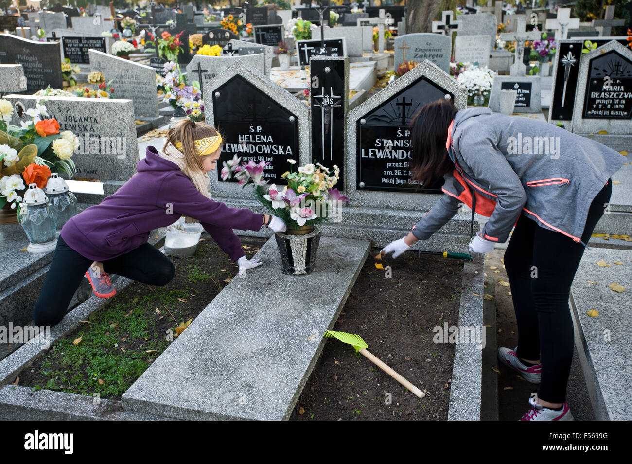 Wielun, Poland. 28th October, 2015. Two women clean up the grave, as a ...