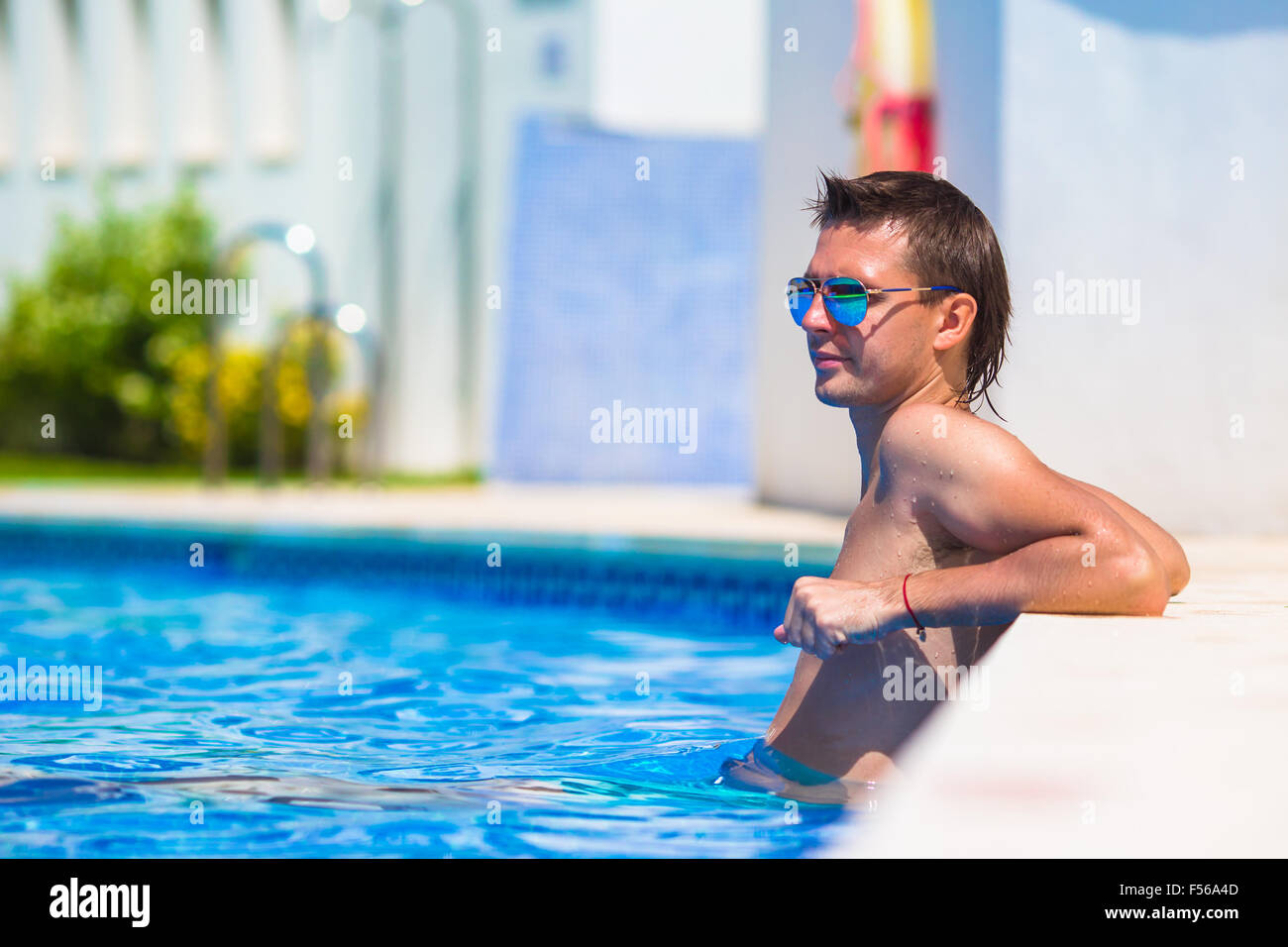 Young happy man relaxing in swimming pool outdoors Stock Photo - Alamy