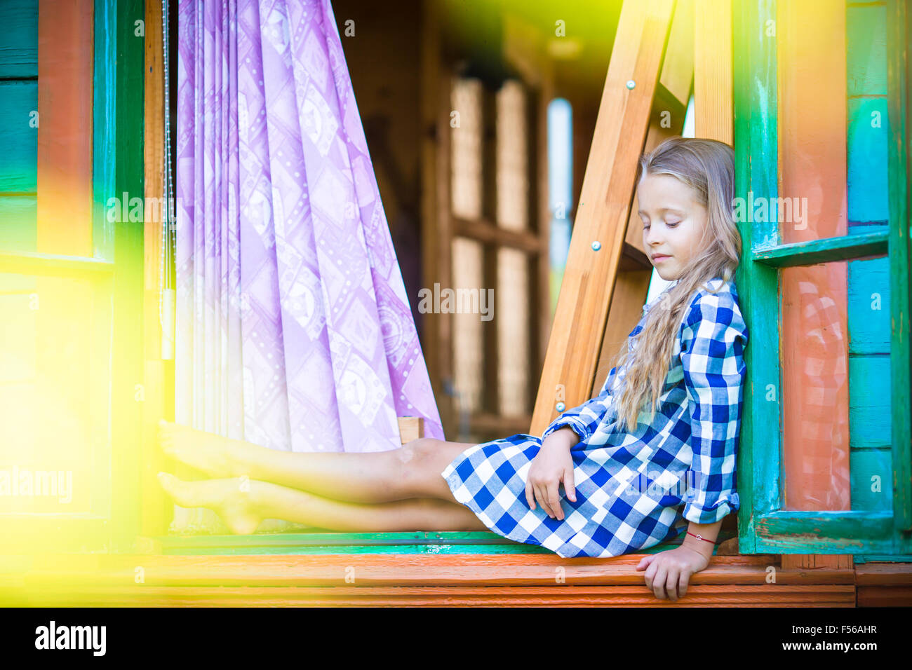 Adorable little girl in the window of rural house outdoors Stock Photo ...