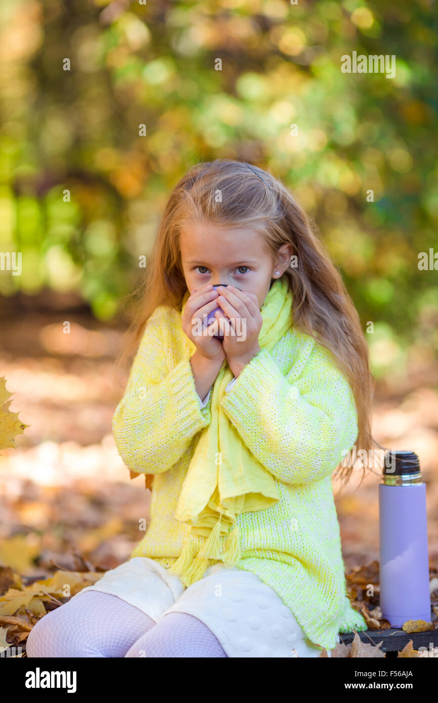 Adorable little girl with hot tea in thermos at beautiful autumn day ...