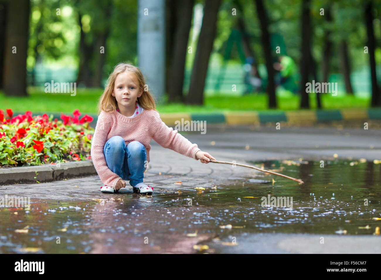 Little happy girl having fun in a large puddle in autumn park Stock ...
