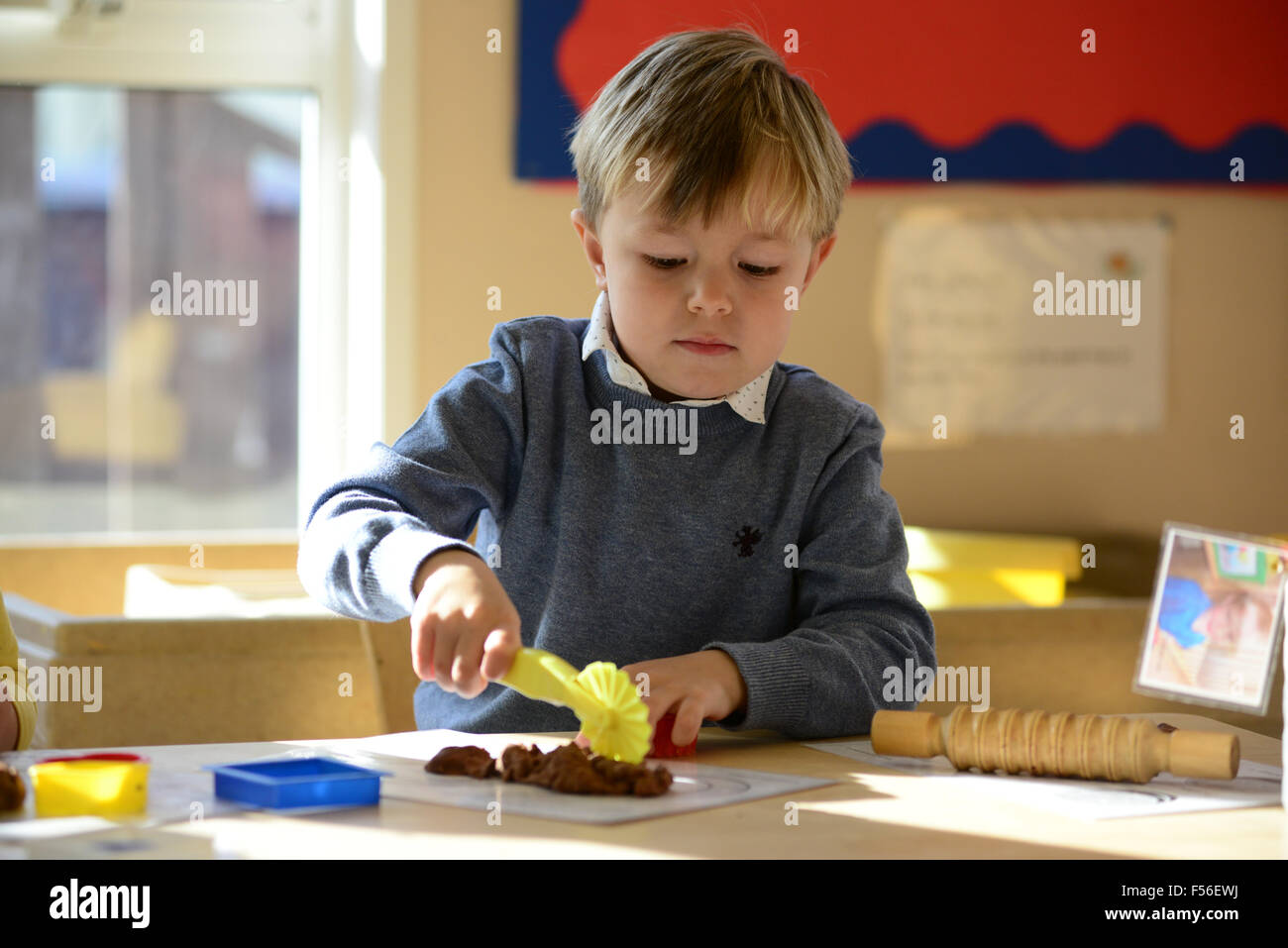 A little boy playing with modelling clay at nursery school Stock Photo ...