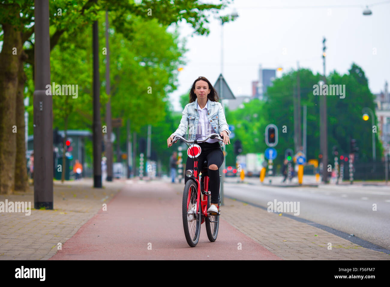 Young happy woman on bike in european city Stock Photo - Alamy