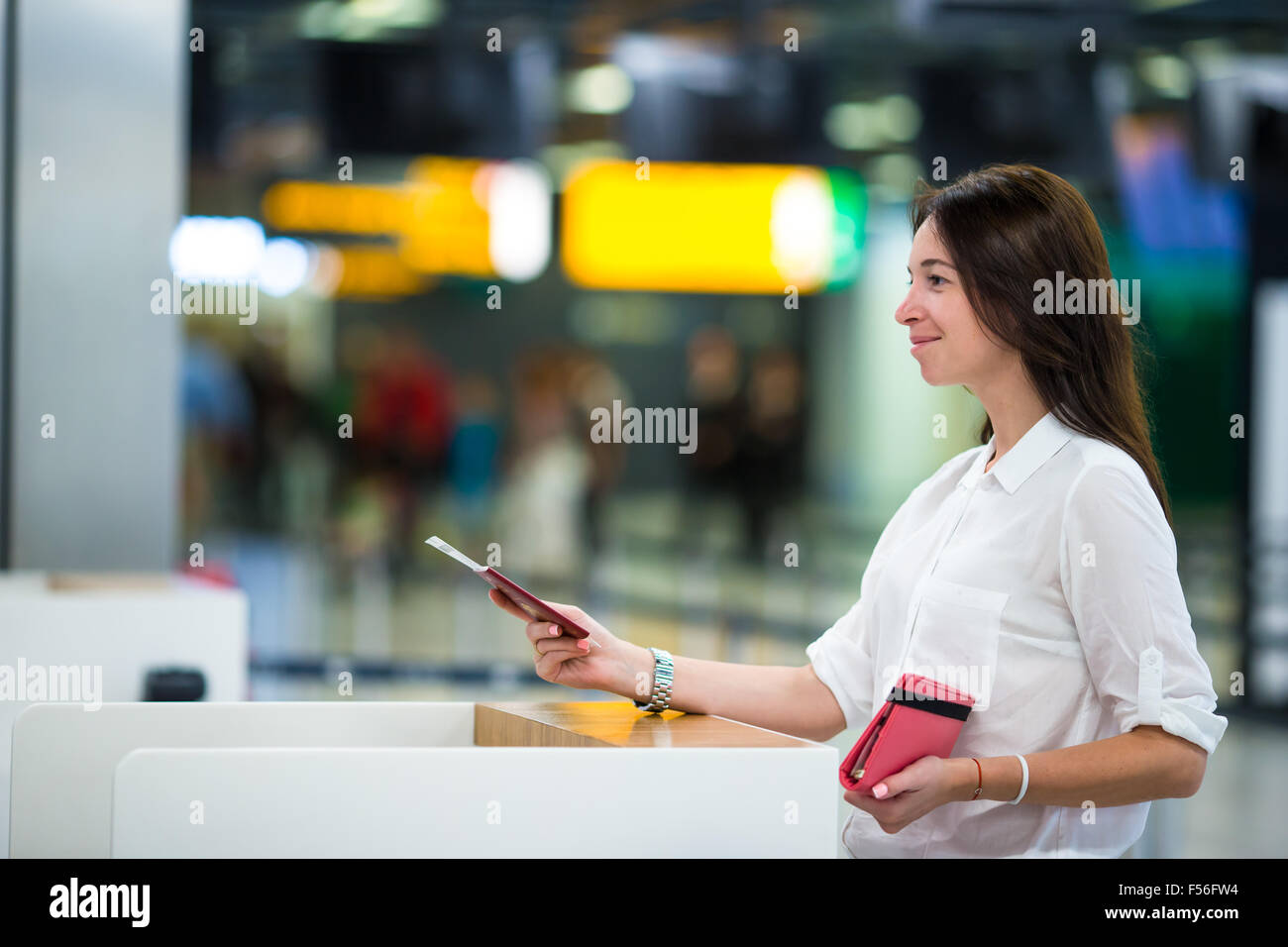 Woman with passports and boarding passes at the front desk at airport ...