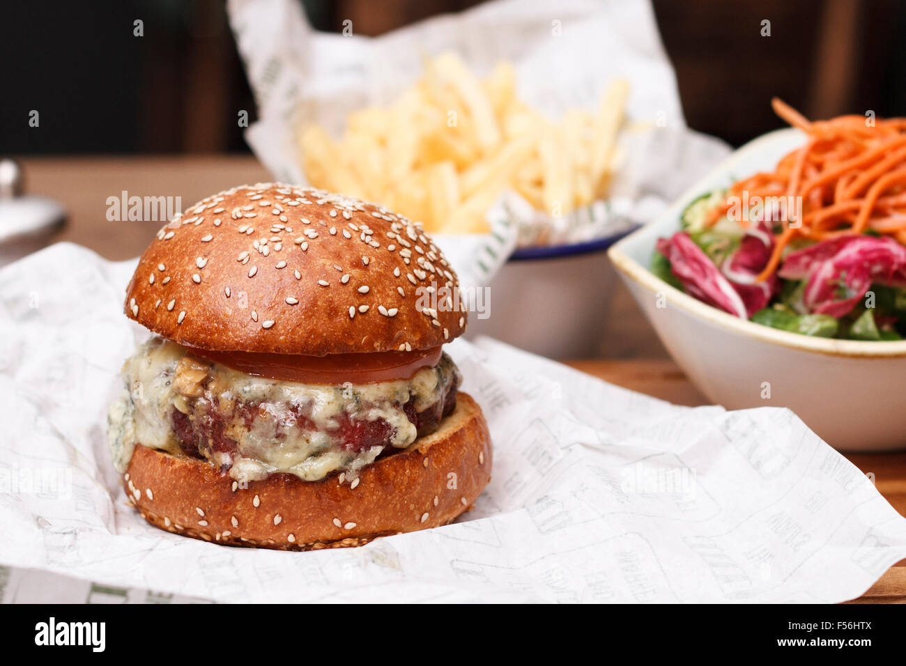Beef Burger in a Sesame Seed Bun with a portion of salad and French ...