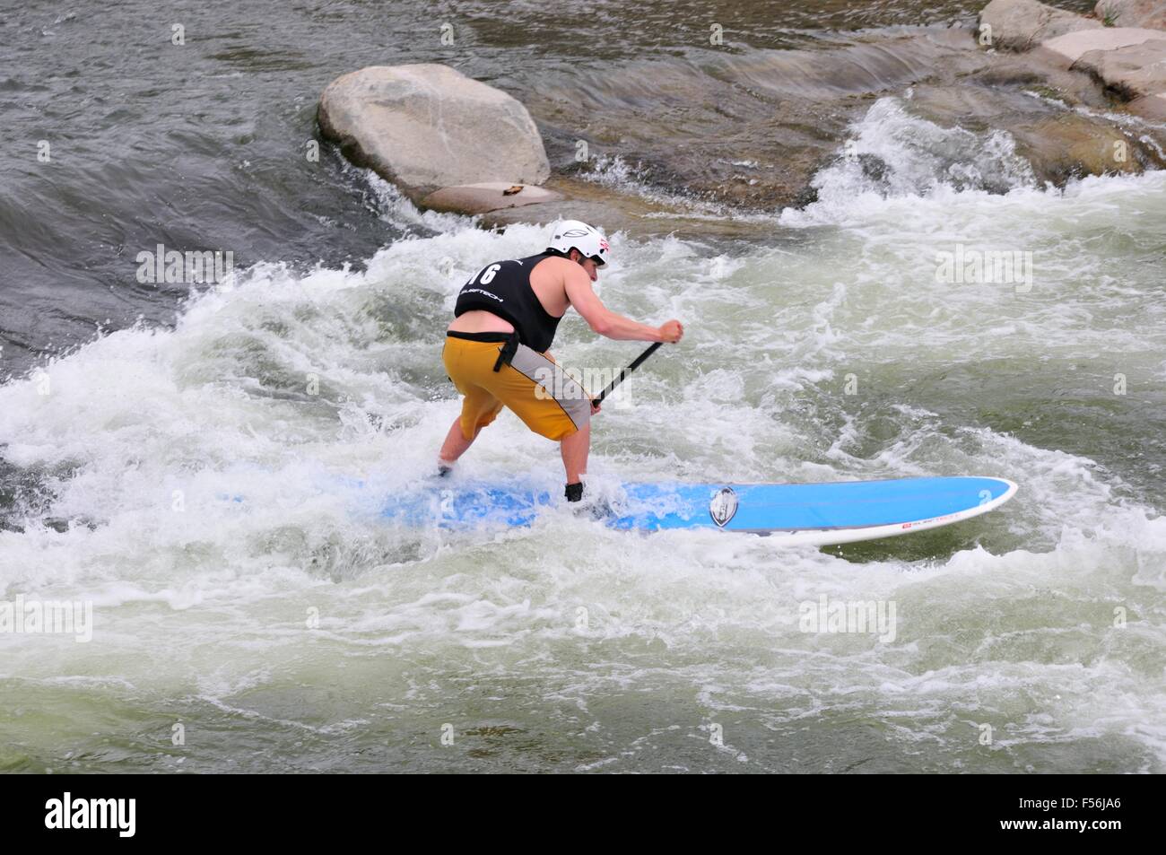 A paddleboarder maneuvers his board through white water during the 2010 ...
