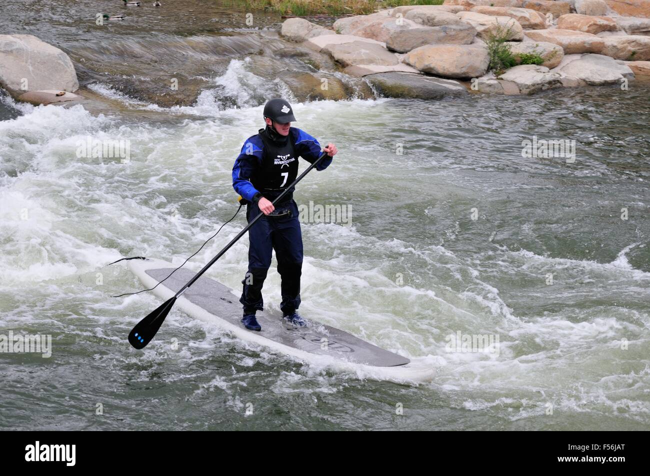 A paddleboarder maneuvers his board through white water during the 2010 ...