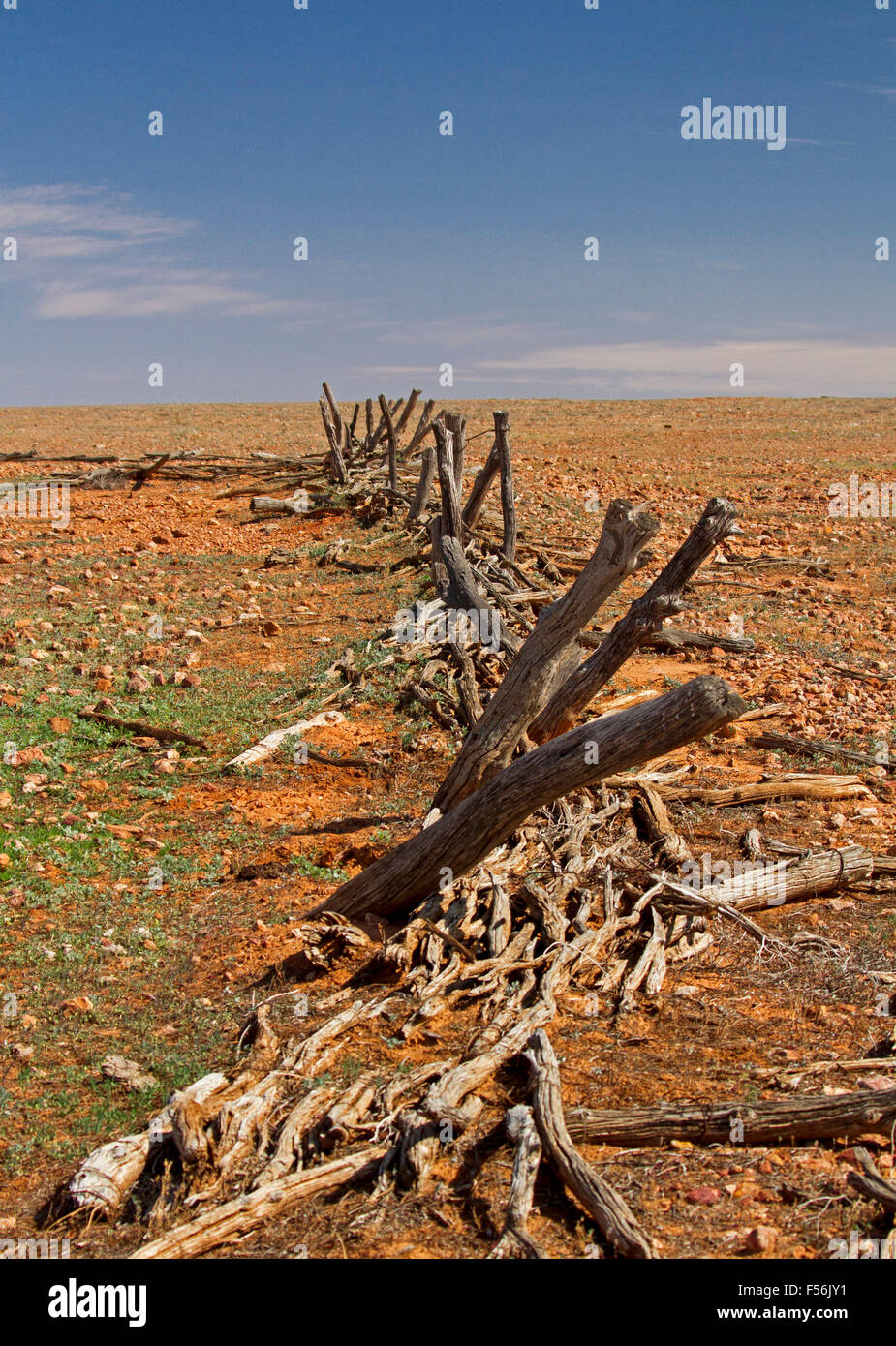 Remains of derelict timber stock yards on barren stony outback plains ...