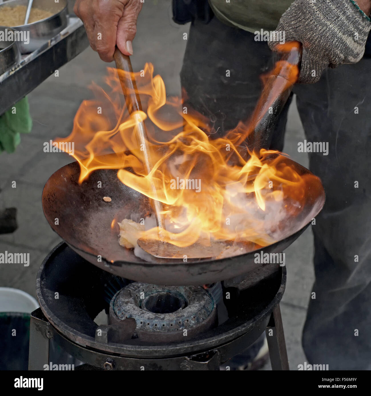 chef cooking with fire in frying pan at outdoor kitchen Stock Photo - Alamy