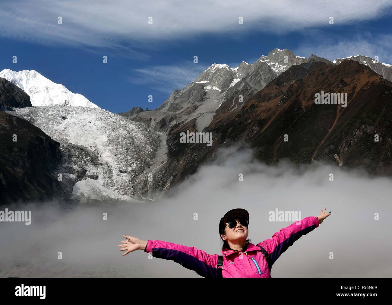 Kangding. 28th Oct, 2015. A tourist poses for photo with Gonggar ...