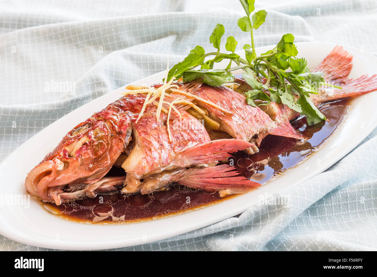 Whole fish steamed and served with sauce Stock Photo - Alamy