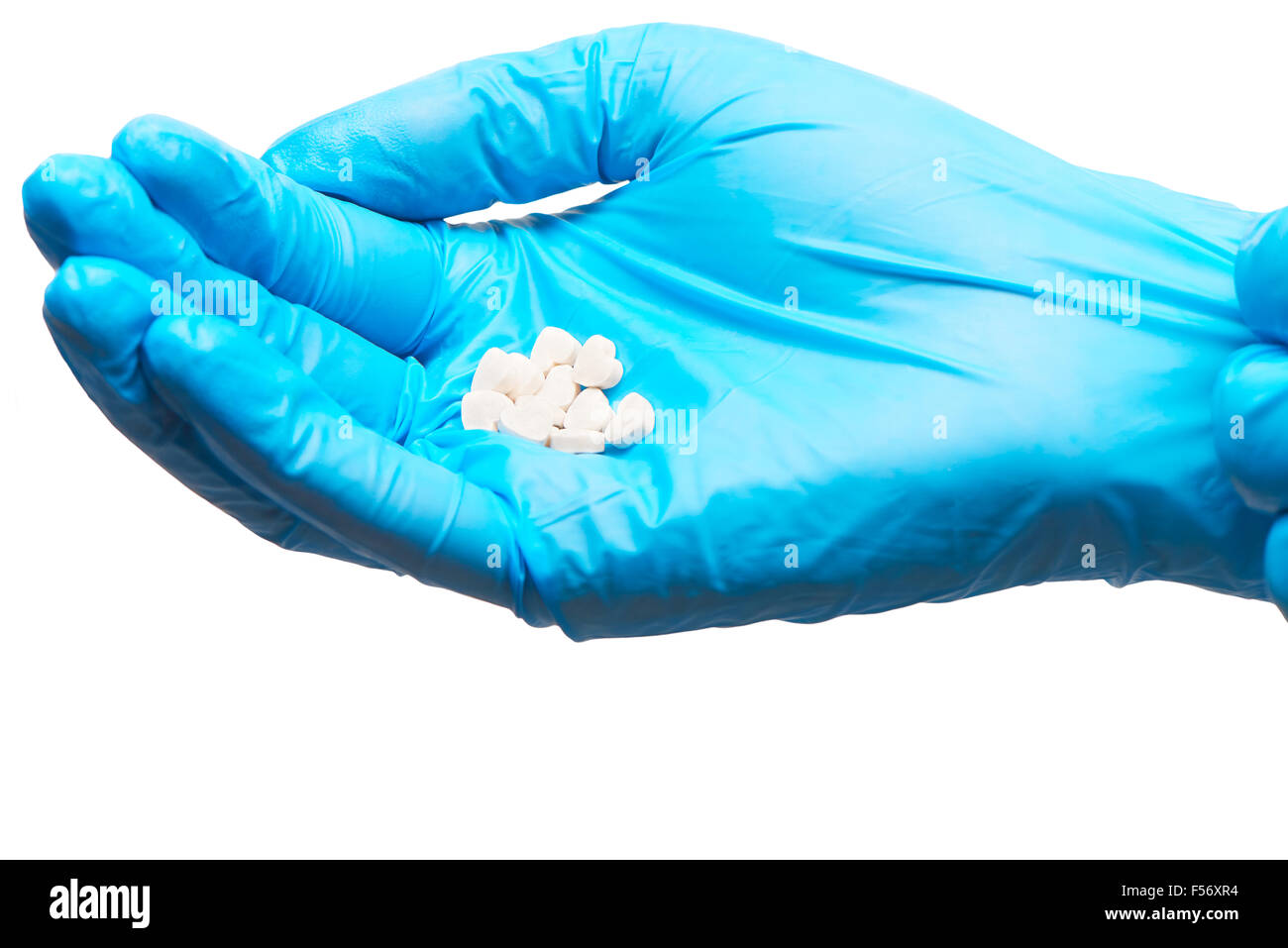 Close up of pile of white heart shape tablets on female doctor's hand ...