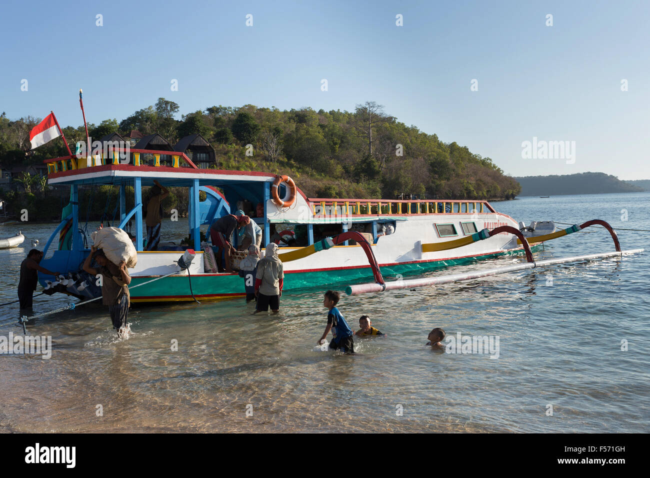 BALI, NUSA PENIDA ISLAND, INDONESIA - JULY 27.2015: Men transports ...