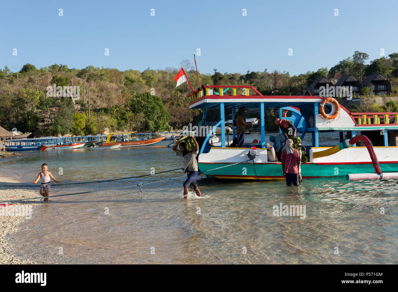 BALI, NUSA PENIDA ISLAND, INDONESIA - JULY 27.2015: Men transports ...