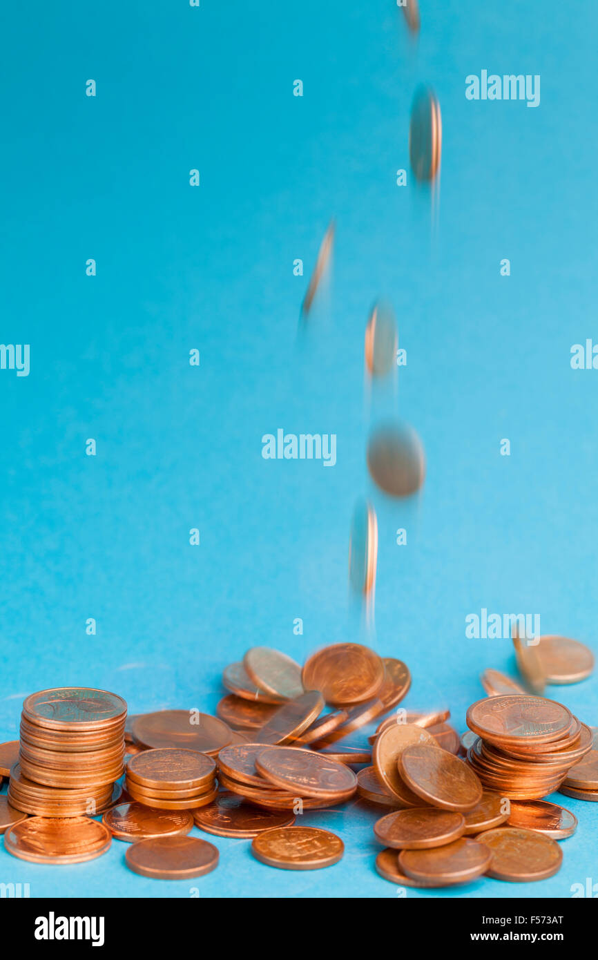 Falling Euro cent coins in one cent and two cents denominations on blue ...