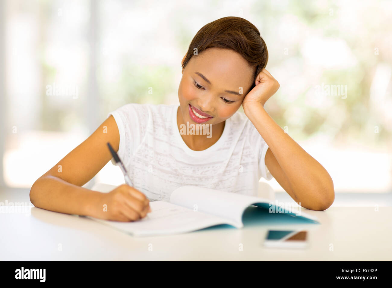 beautiful African college student writing homework at home Stock Photo ...