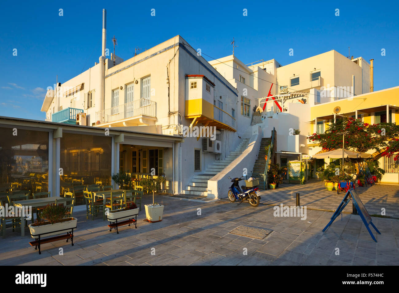 Coffee shop and shops on the seafront of Adamantas village early in the ...