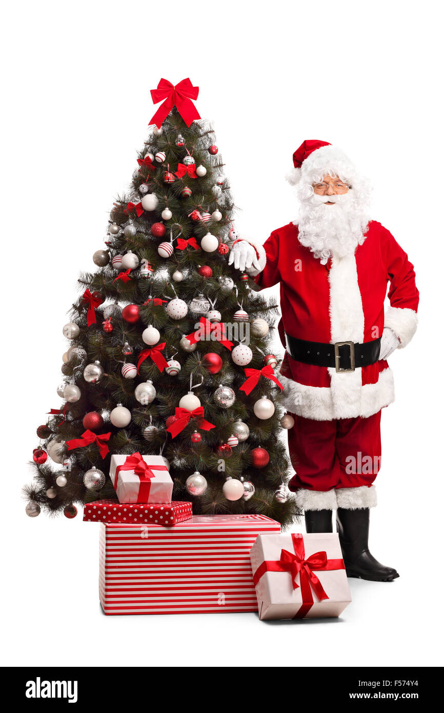 Full length portrait of Santa Claus standing next to a Christmas tree ...