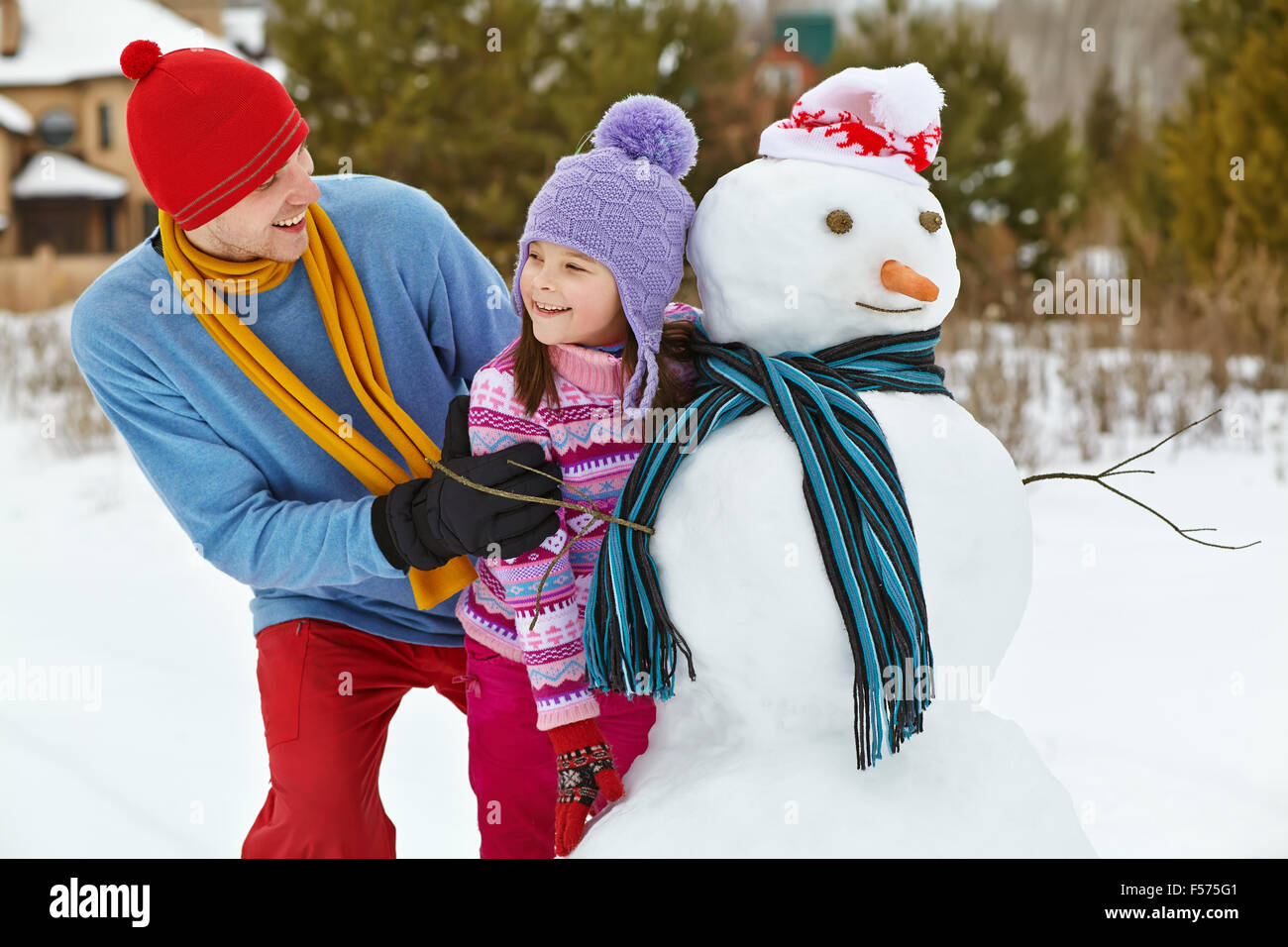 Father and daughter with snowman Stock Photo - Alamy
