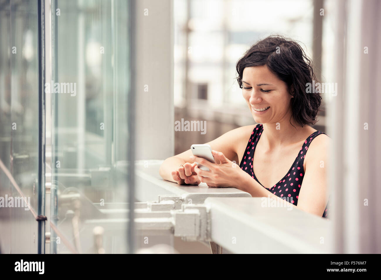 A woman standing outdoors checking her cell phone Stock Photo - Alamy