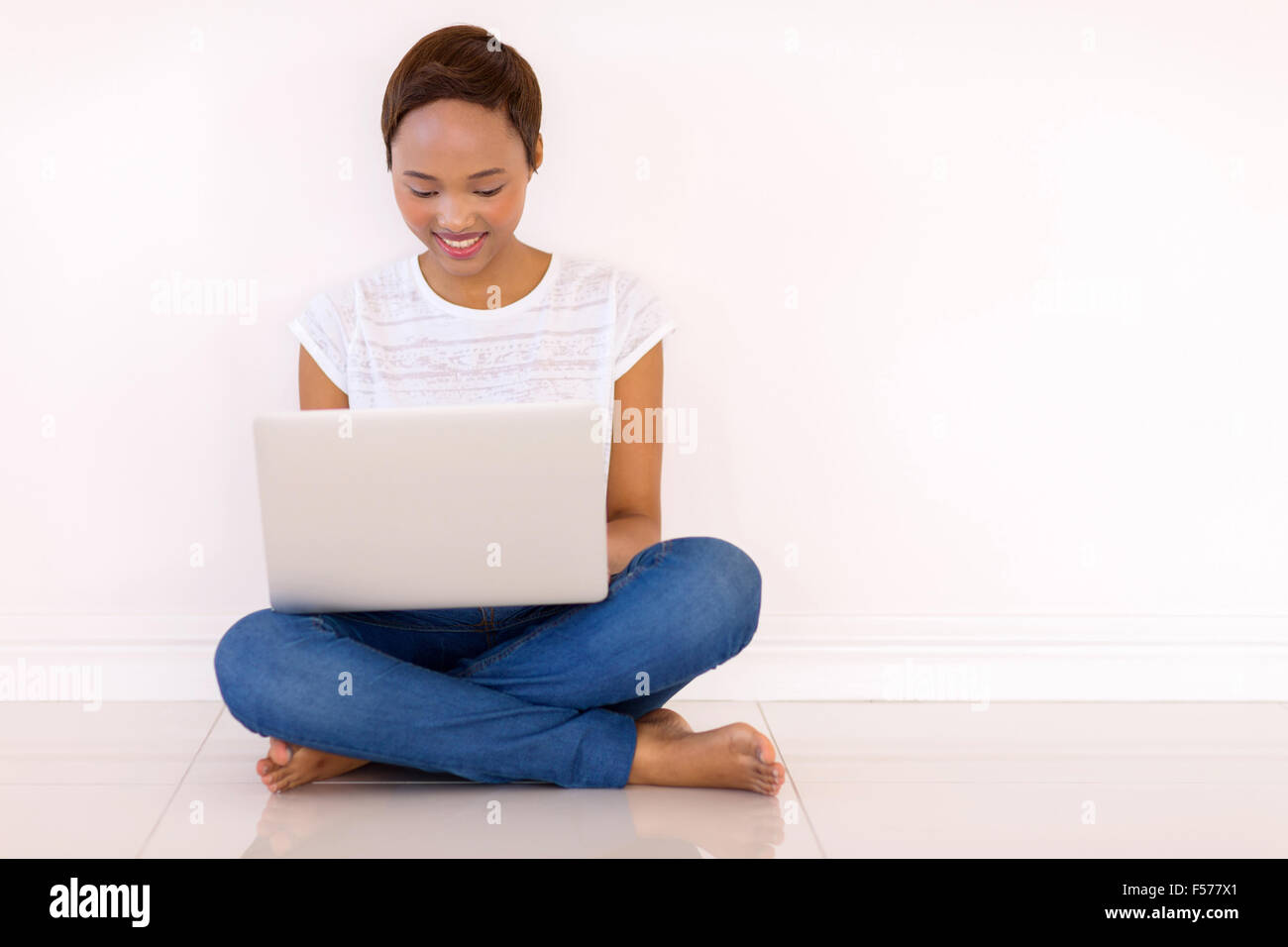 beautiful young African woman reading emails on laptop at home Stock ...