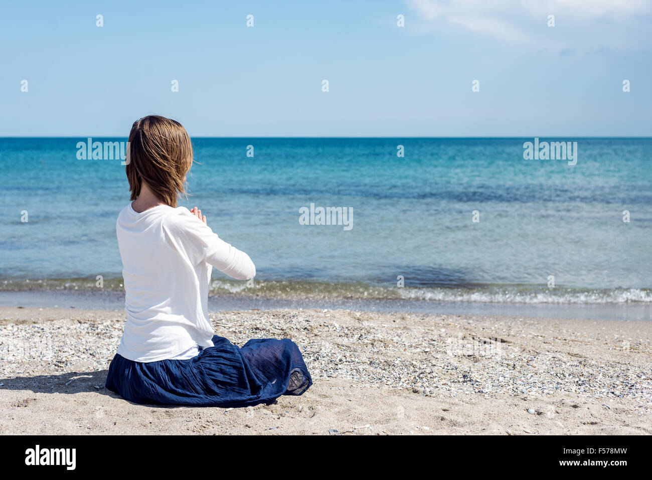 Woman meditating at the sea Stock Photo - Alamy