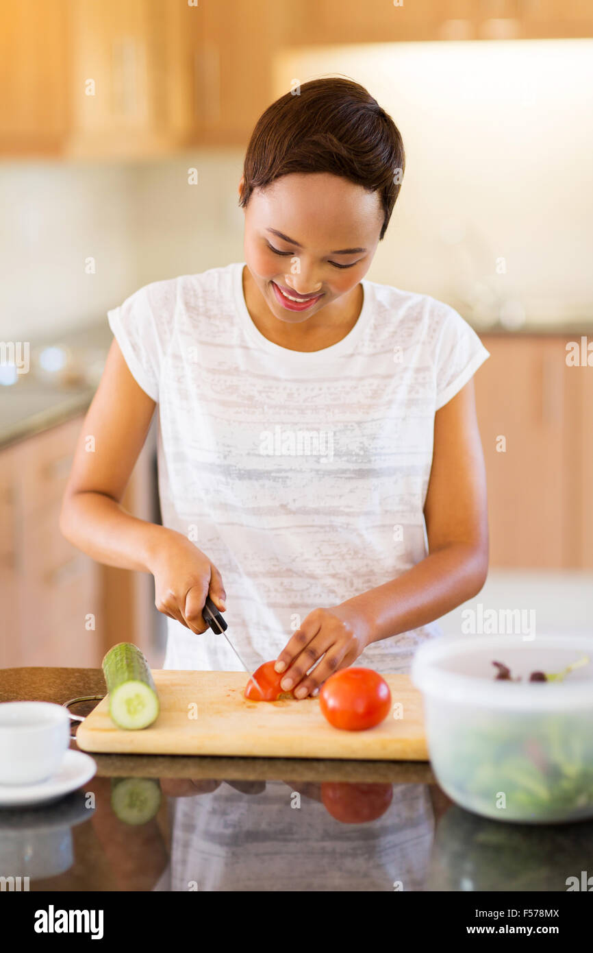 cheerful young African woman cooking in kitchen Stock Photo - Alamy