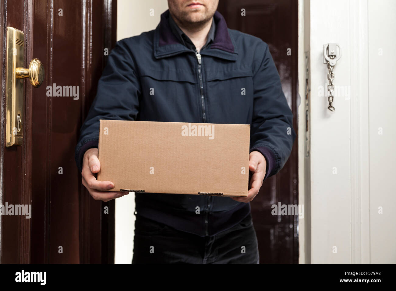 Postman delivers parcel Stock Photo - Alamy