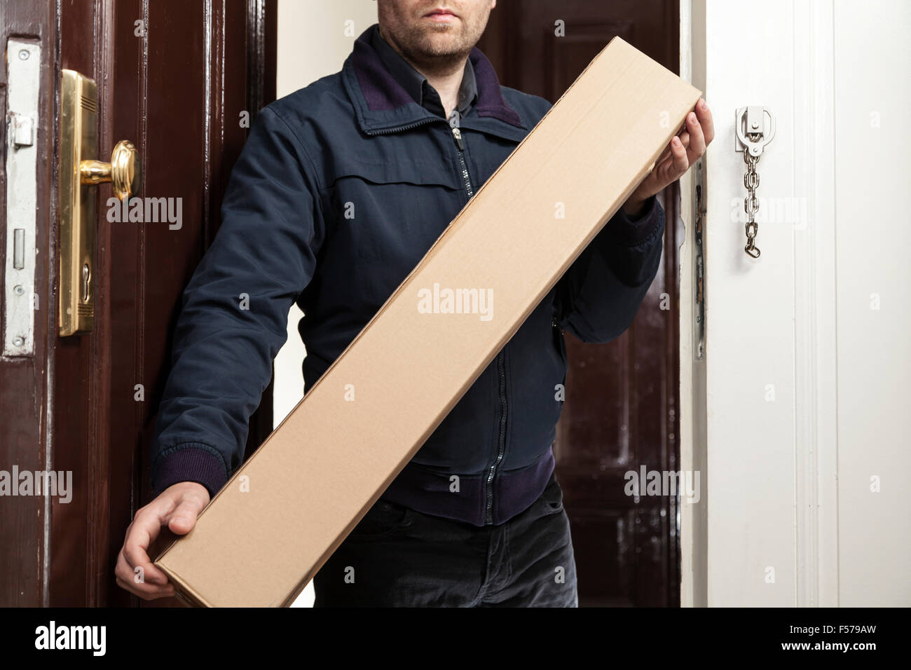 Postman brings a parcel in special size Stock Photo - Alamy