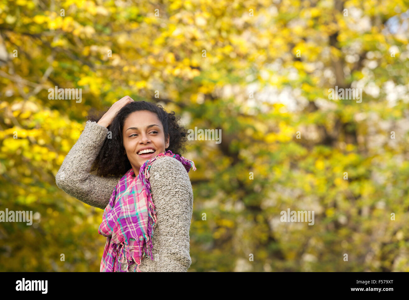 Portrait of a happy young woman laughing with hand in hair Stock Photo ...