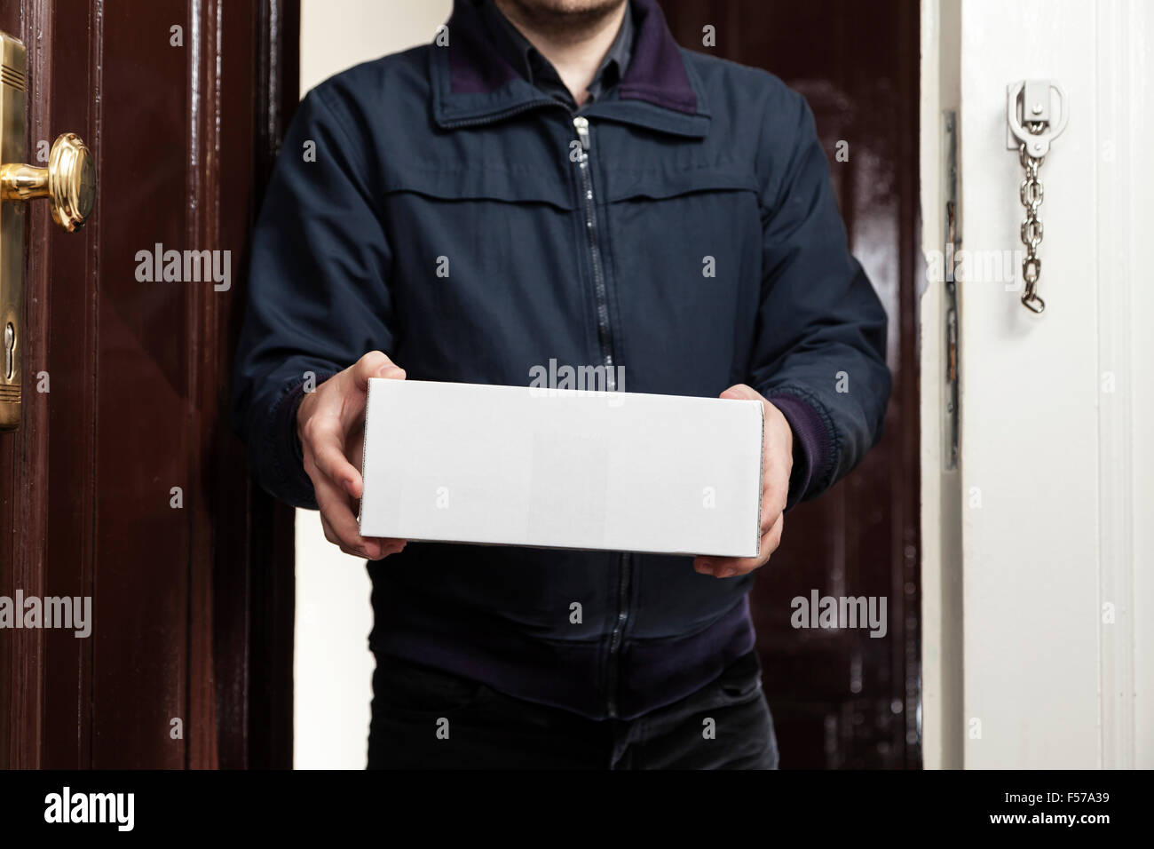 Postman brings a white package Stock Photo - Alamy