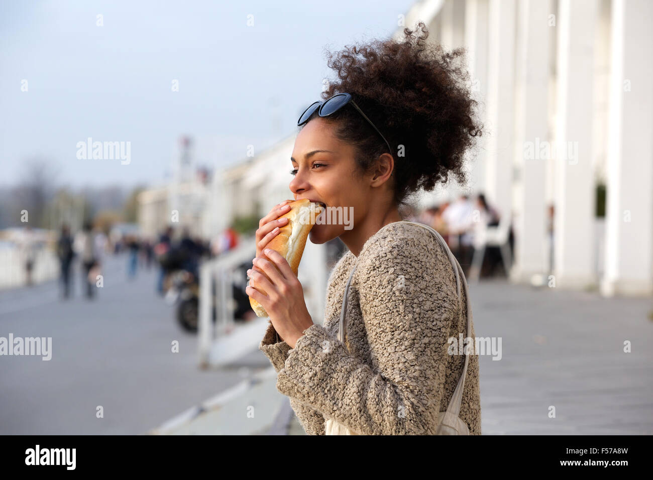 Side view portrait of a young woman eating junk food Stock Photo - Alamy