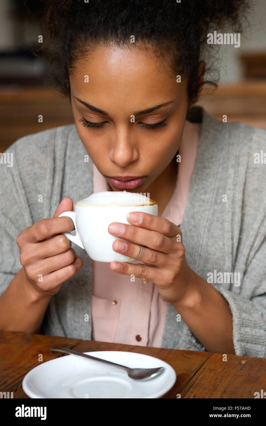 Close up portrait of a young african american woman drinking cup of ...