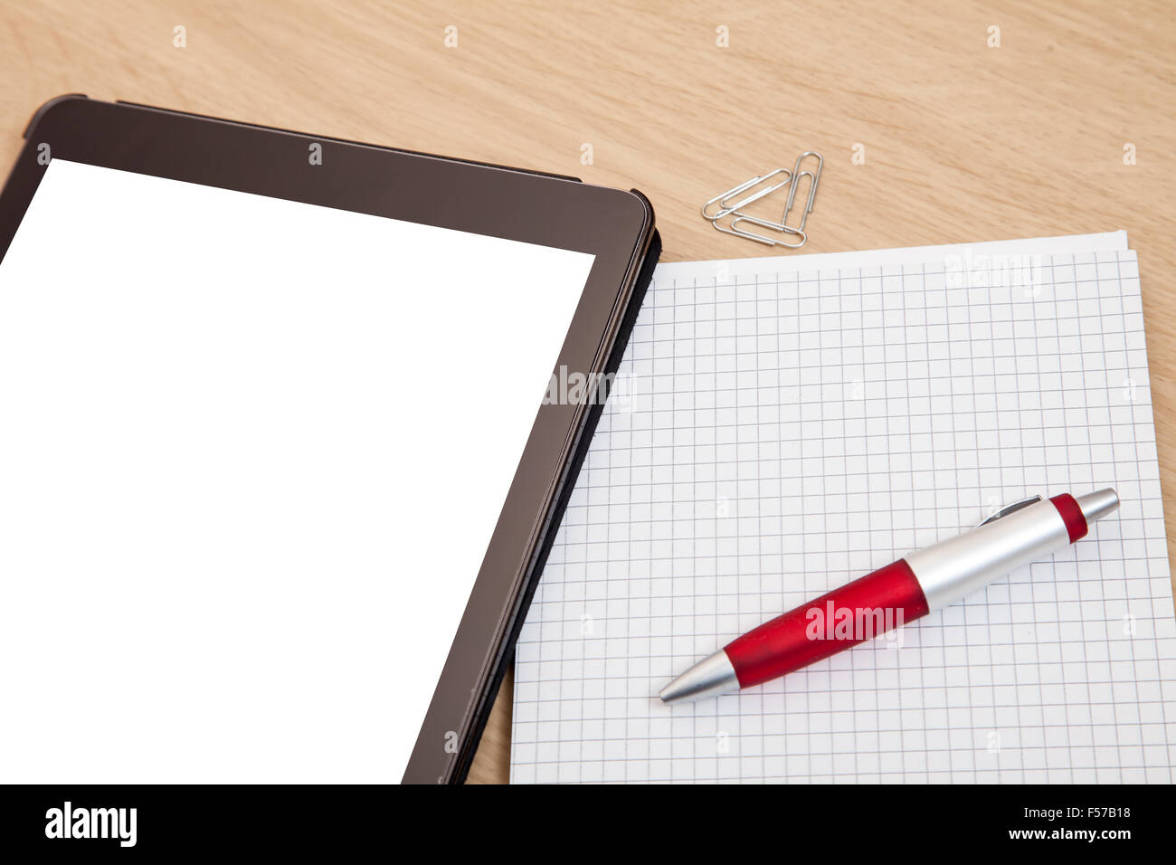 Tablet device with blank display next to notepad Stock Photo - Alamy