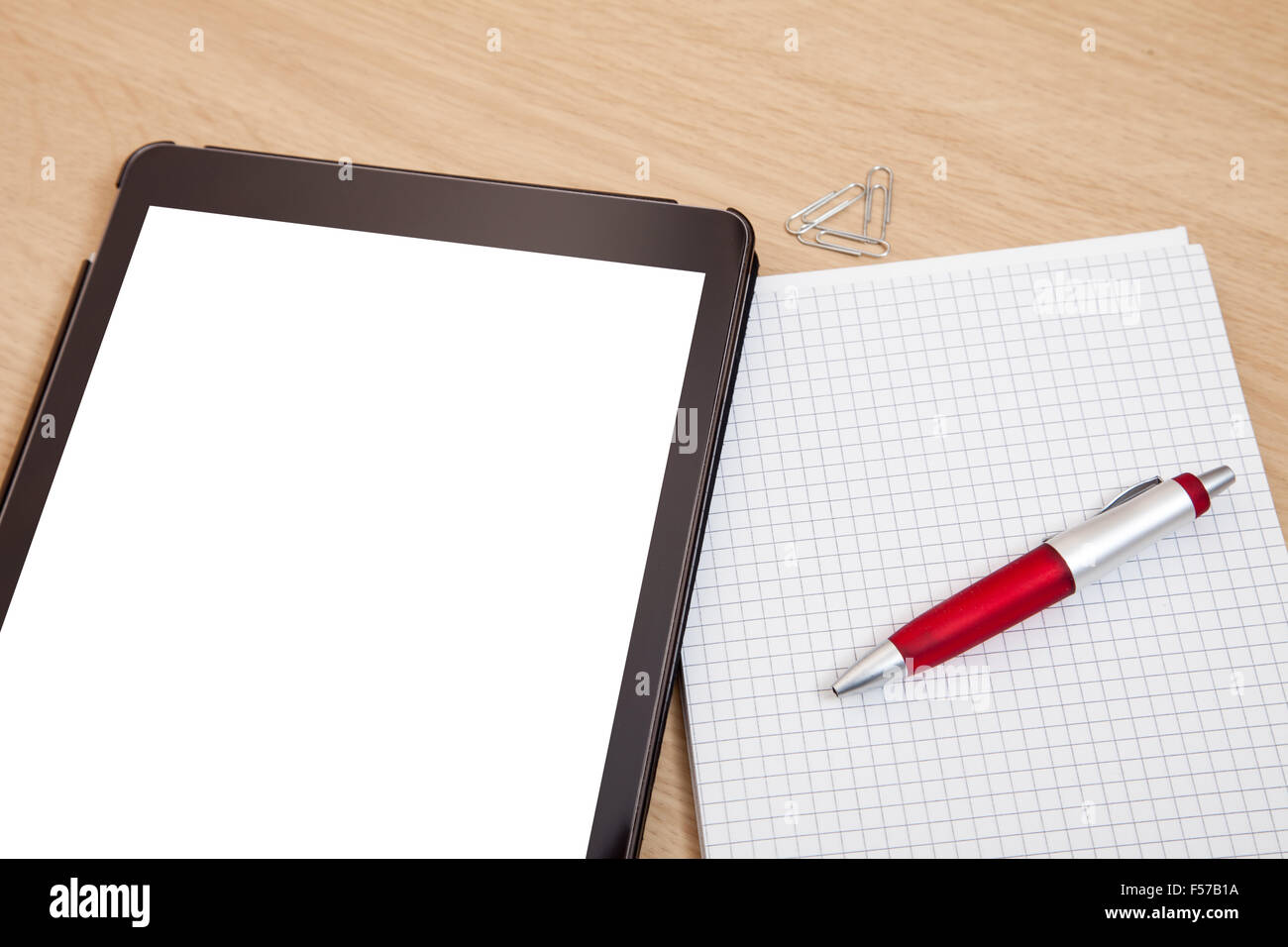 Tablet device with blank display next to notepad Stock Photo - Alamy