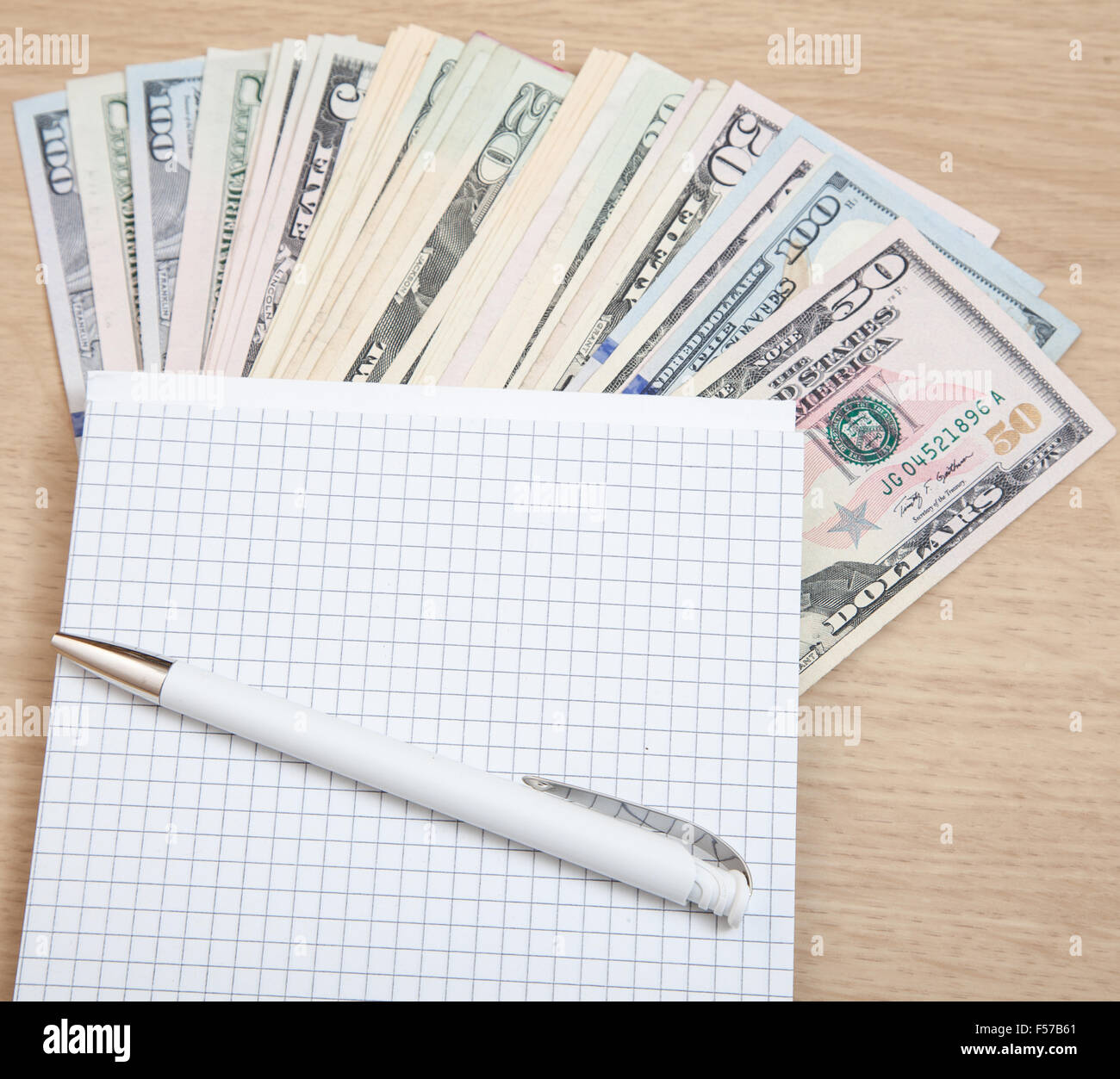 Various dollar notes next to notepad on desk Stock Photo - Alamy