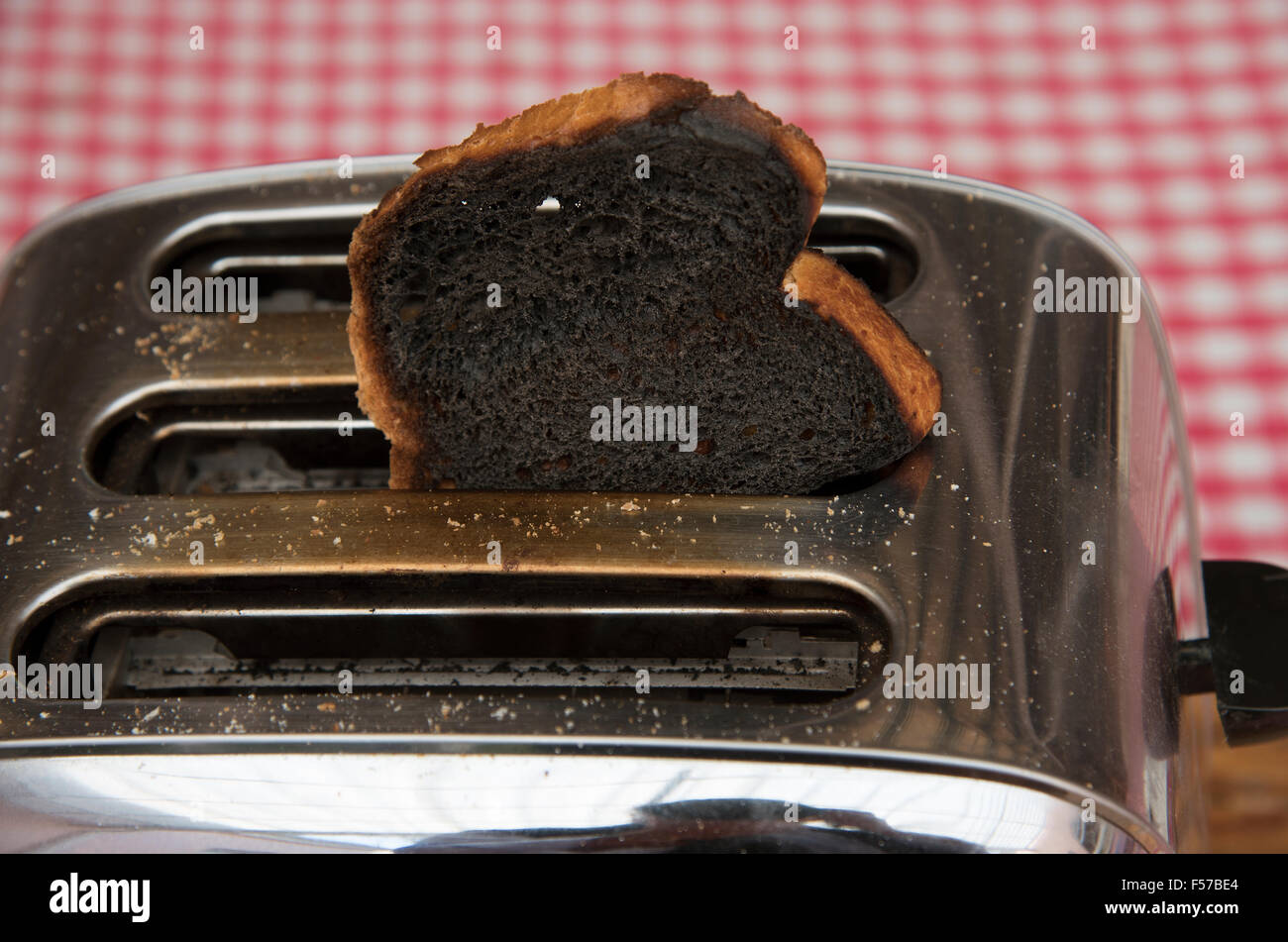 Slice of burnt toaster being removed from a toaster Stock Photo - Alamy