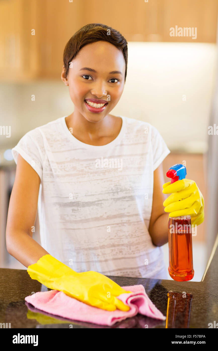 happy young African American woman cleaning kitchen counter Stock Photo ...