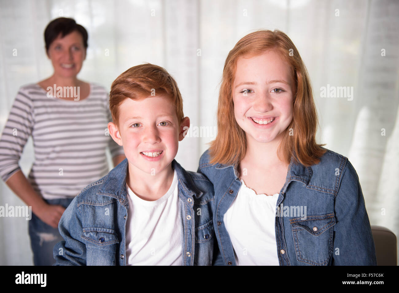 two happy children with mother in the background Stock Photo - Alamy