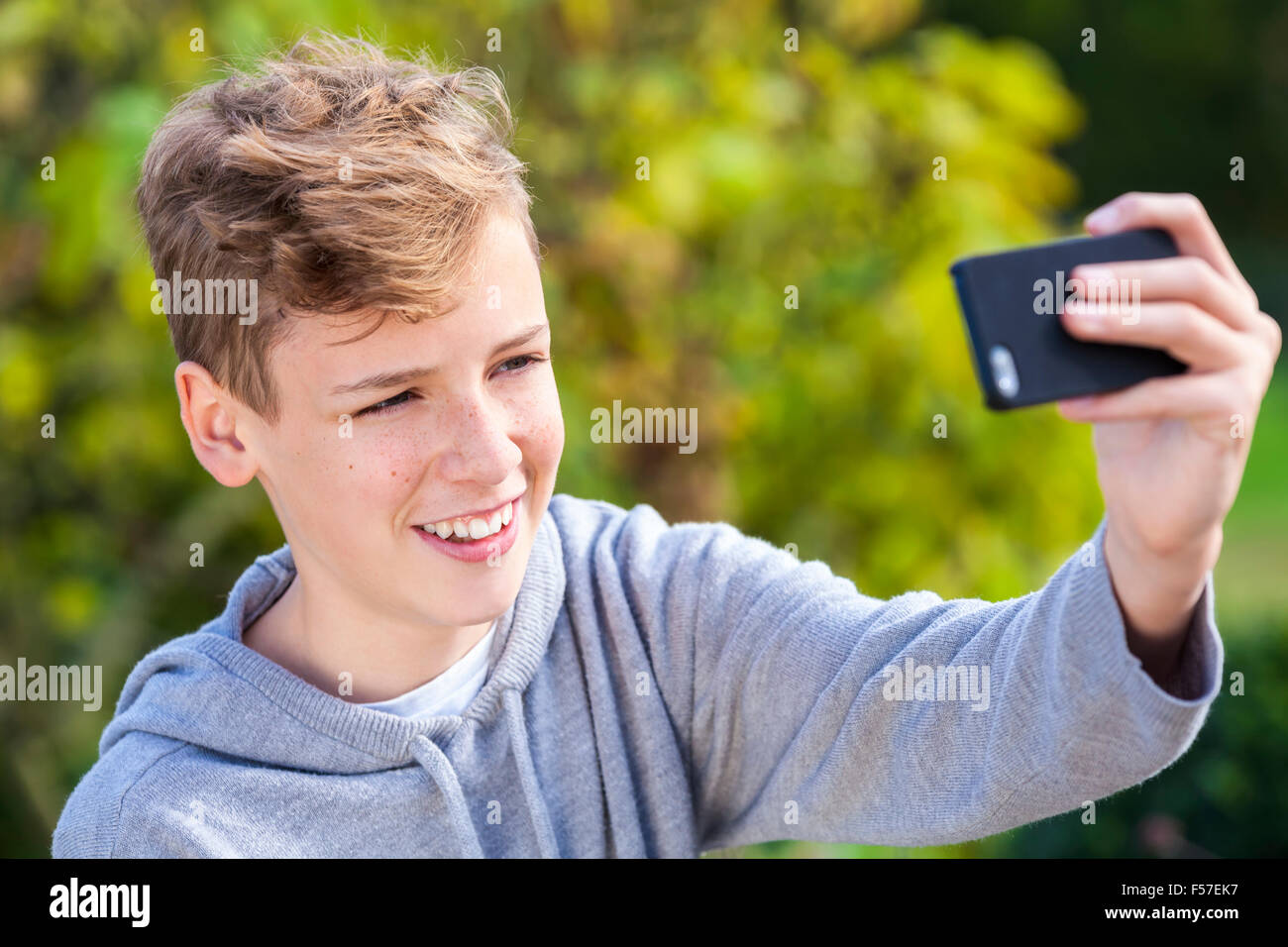 Male teenager boy teen child smiling and taking selfie photograph with ...