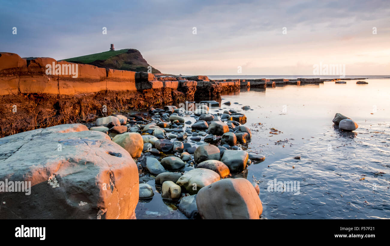 Natural rock pier capturing sunset glow Stock Photo - Alamy