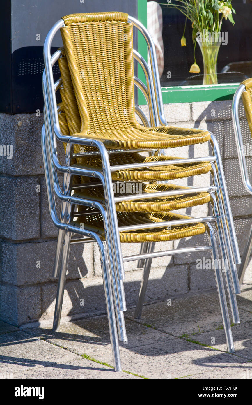 Stack of chairs outside cafe Stock Photo - Alamy