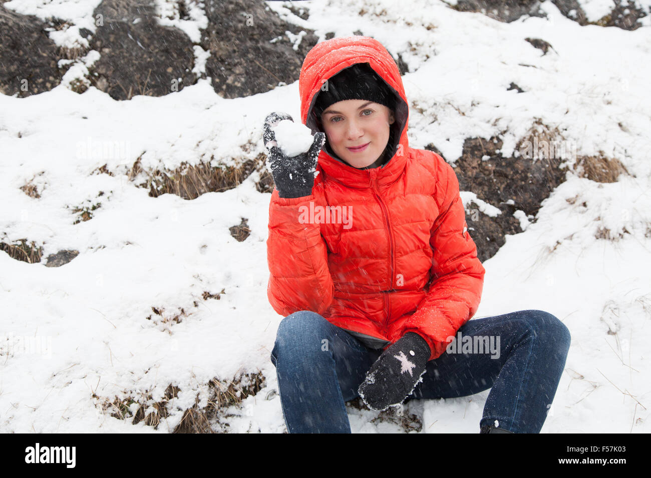 Pretty young woman playing snowballs Stock Photo - Alamy