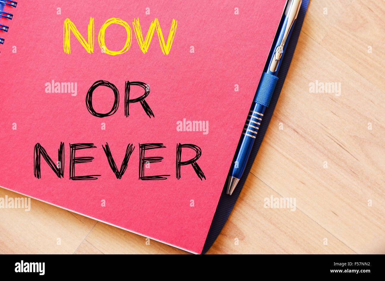Now or never text concept write on notebook Stock Photo - Alamy
