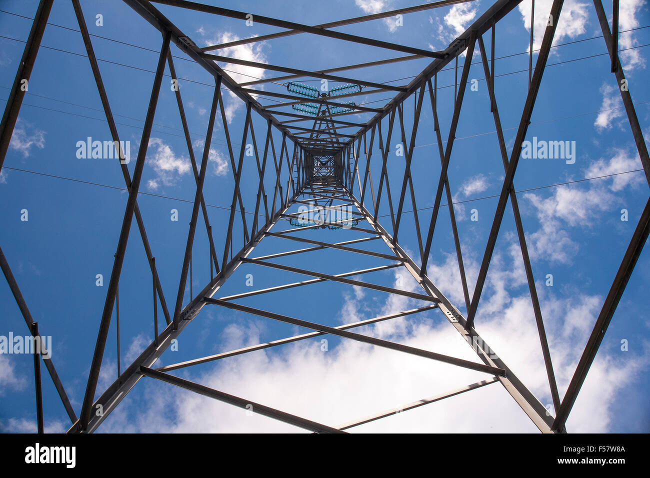 Electricity pylon looking upwards against a blue sky power cables Stock ...